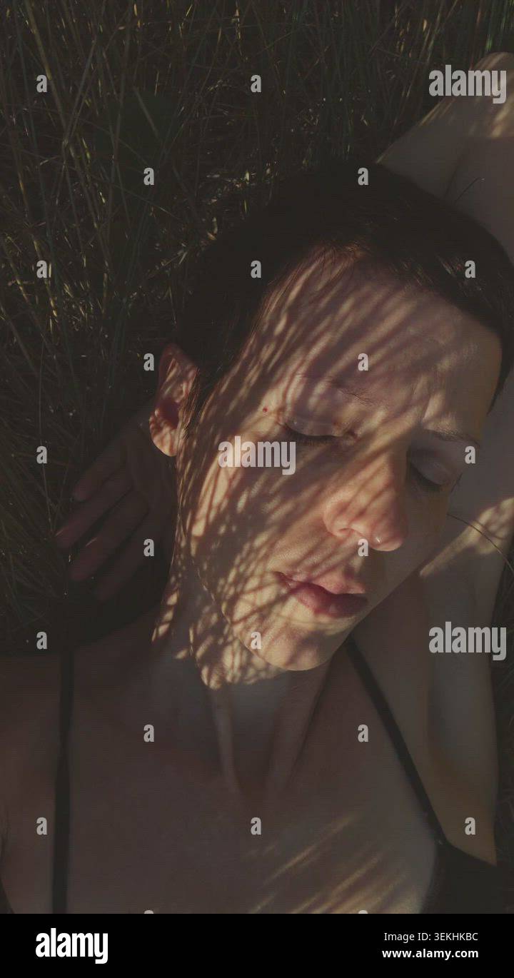 Beach Grass Shadow and Light on Woman's Face Stock Video Footage - Alamy