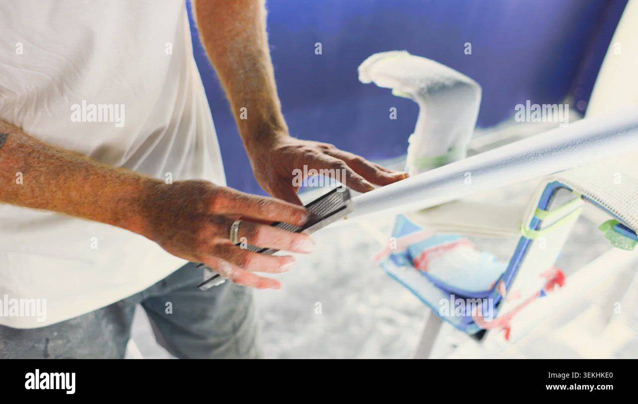 Fixed close-up shot of surfboard shaper refining tail with rasp tool ...