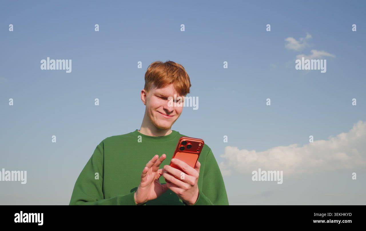 Smiling Man Using Phone Under Blue Sky Stock Video Footage - Alamy
