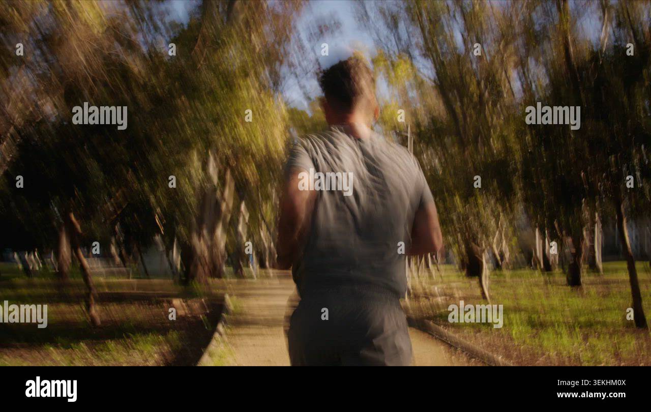 Back view of man running fast with motion blur in park Stock Video ...