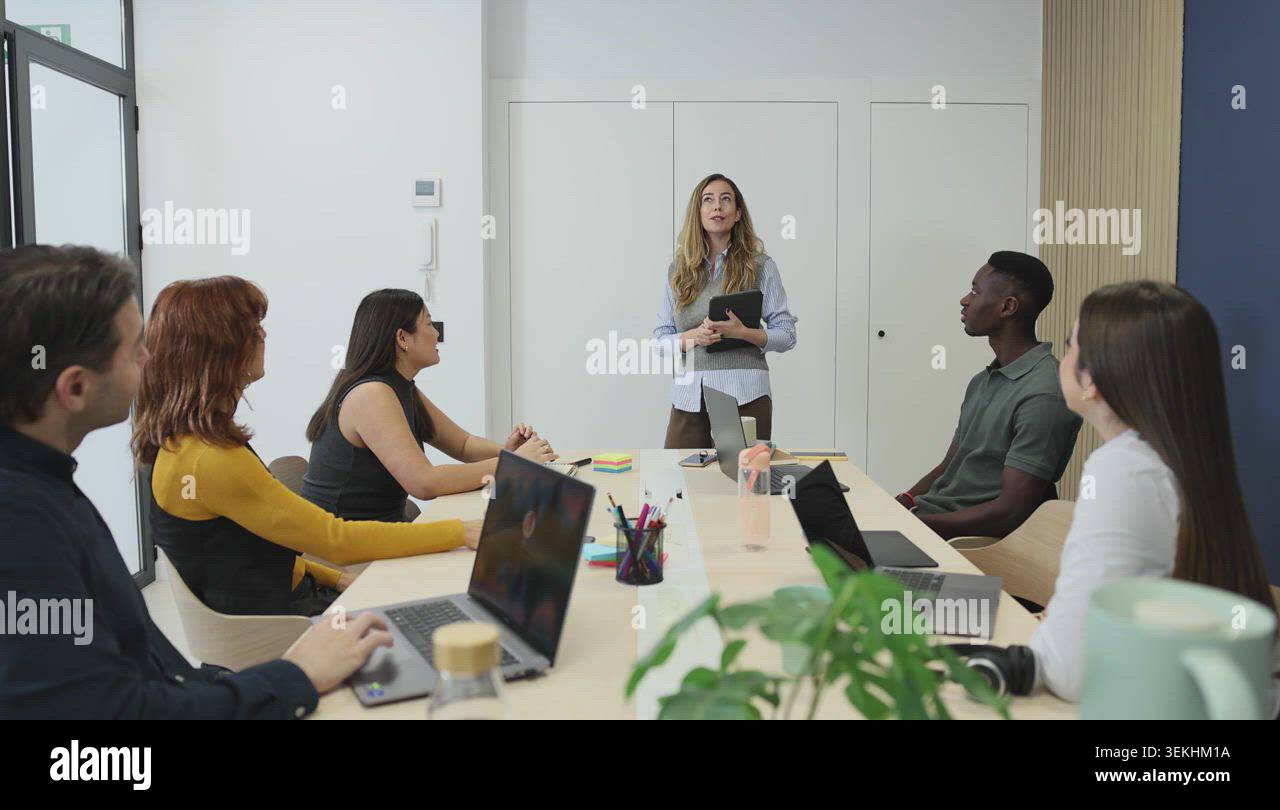 Female team leader presenting a project to diverse colleagues Stock ...