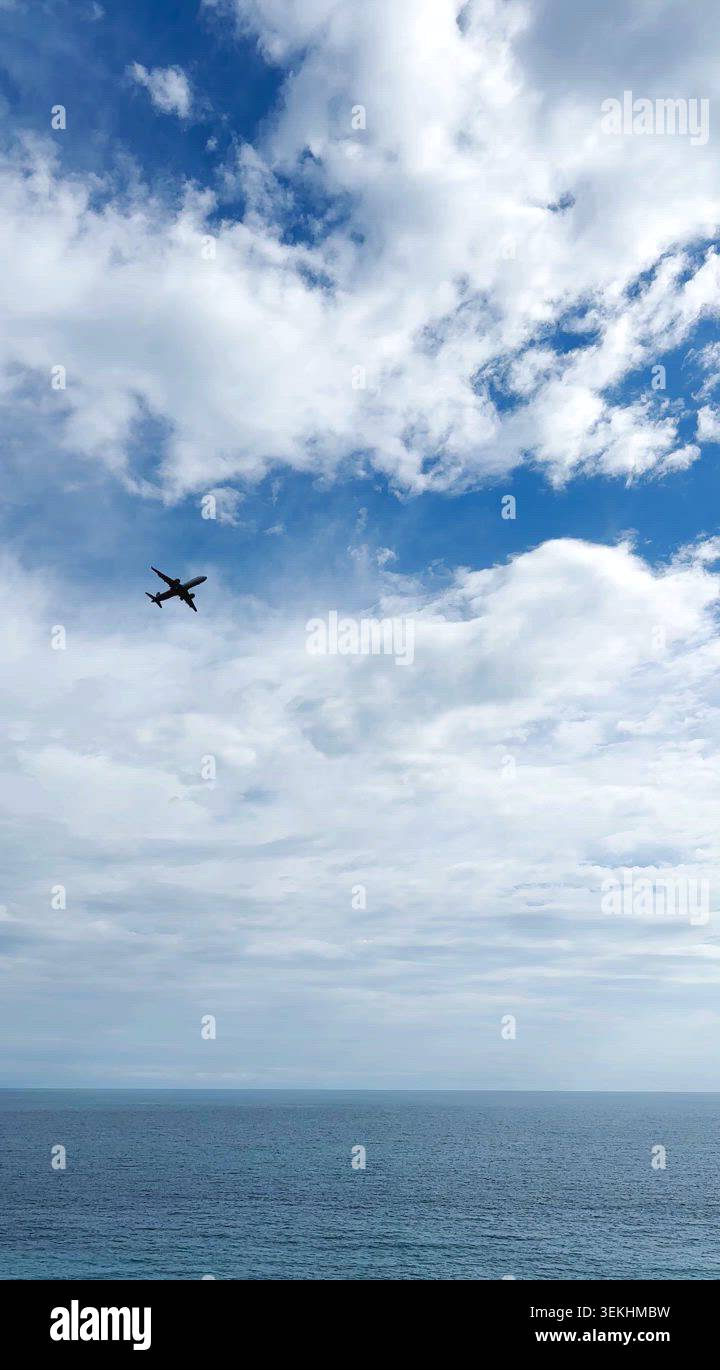 Airplane flying over the sea and blue sky with white clouds Stock Video ...