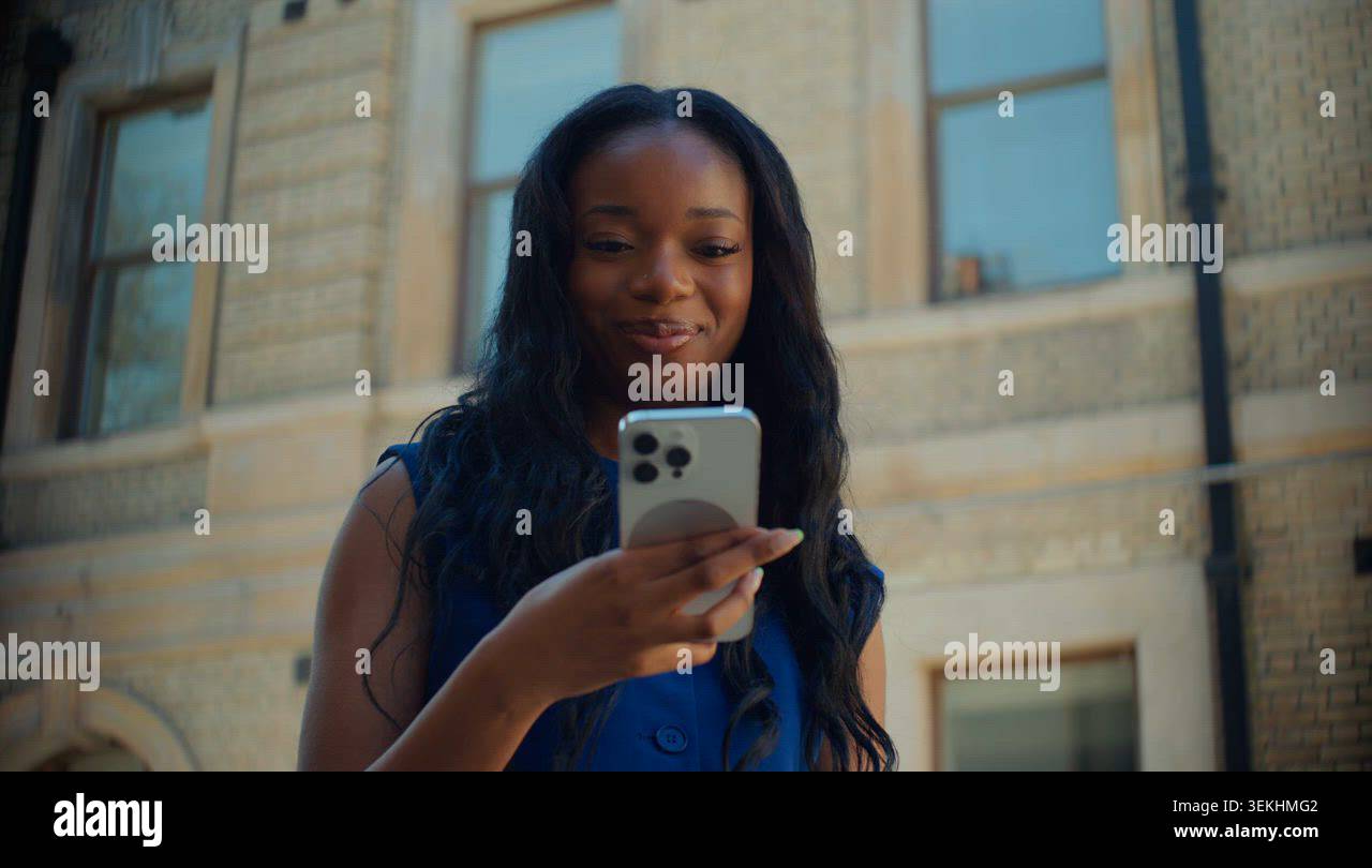 a woman texting while smiling at her phone Stock Video Footage - Alamy