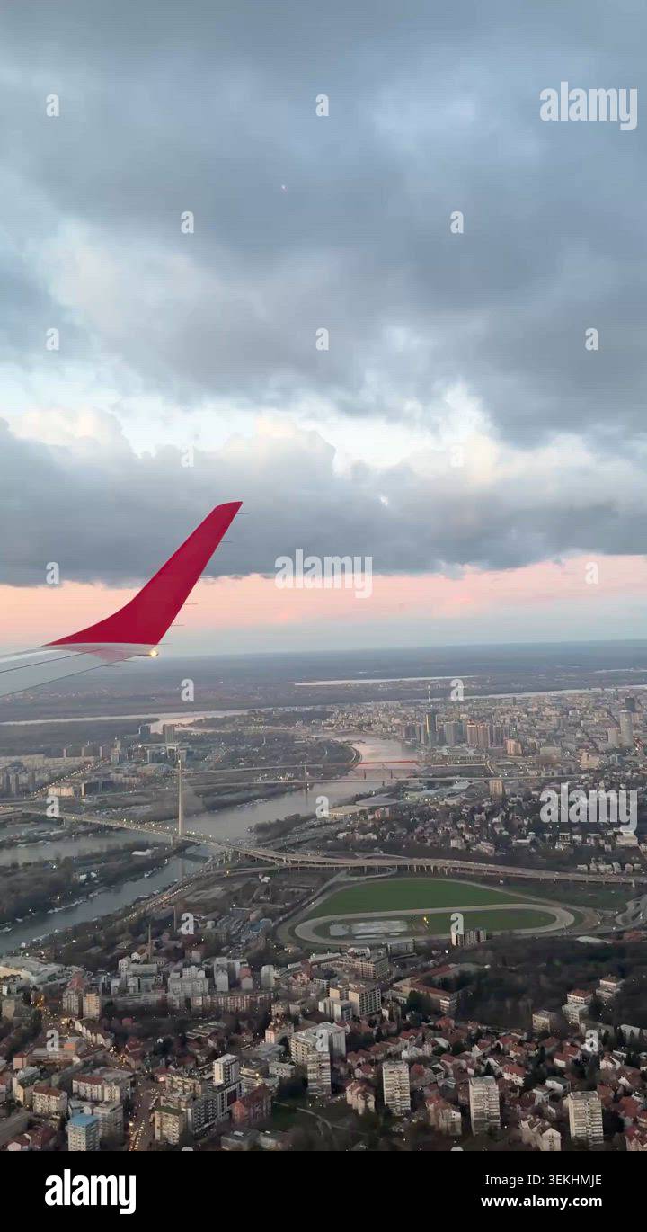 Aerial view of a city with an airplane wingtip at sunset Stock Video ...