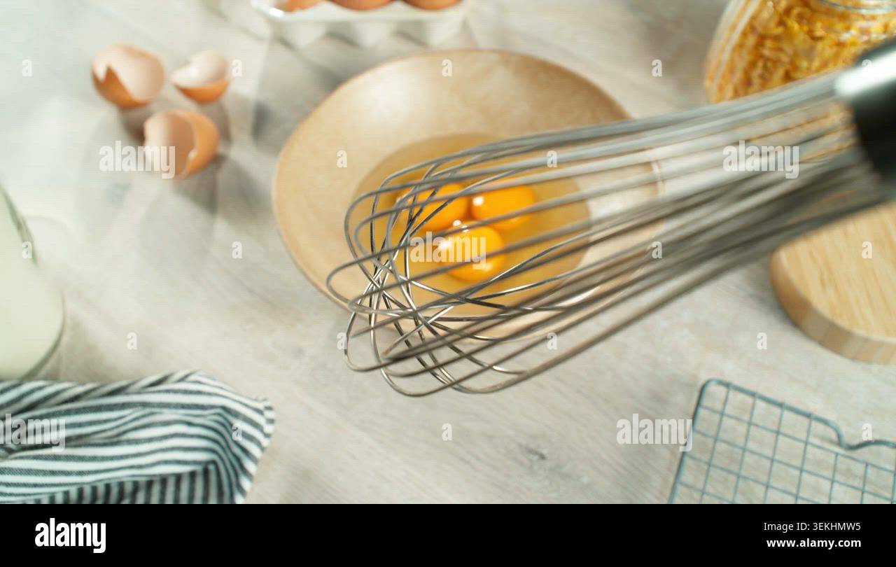 Whisking eggs for cooking in the kitchen Stock Video Footage - Alamy