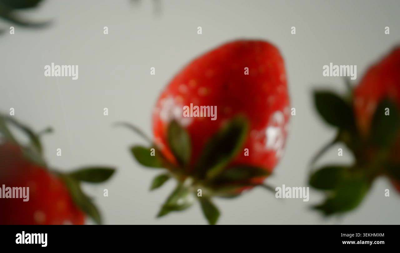 Strawberries splashing into milk Stock Video Footage - Alamy