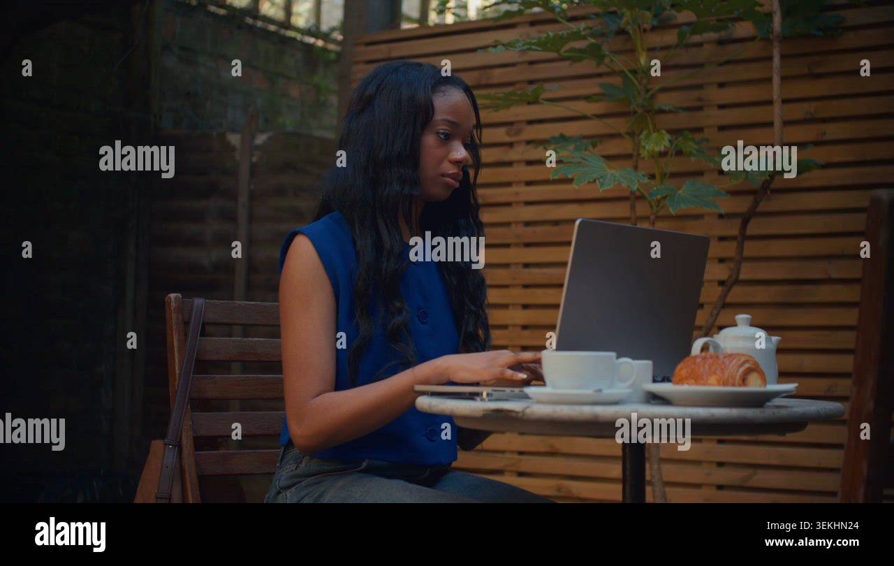 Woman Working on Laptop at a Cafe Table in an Outdoor Setting Stock ...