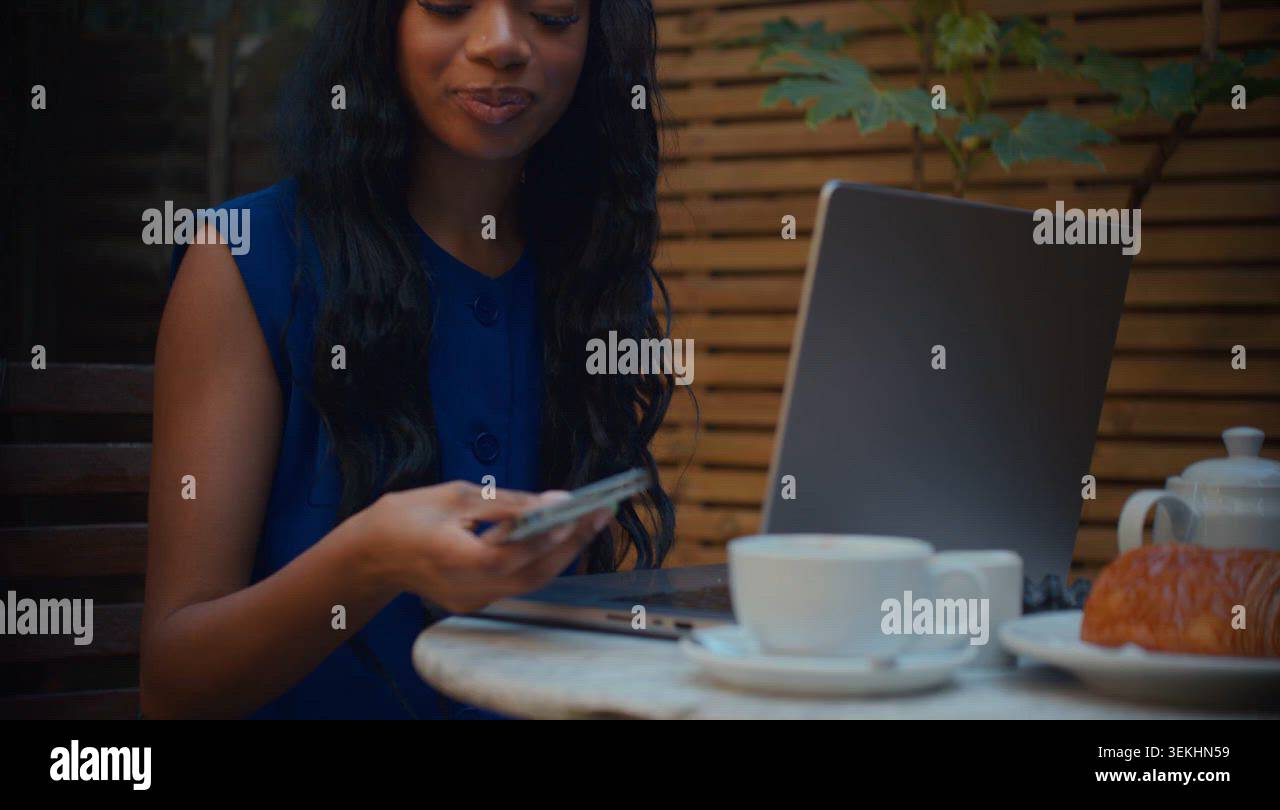 Woman on Facetime on Phone and Laptop at a Table in a Cafe Stock Video ...