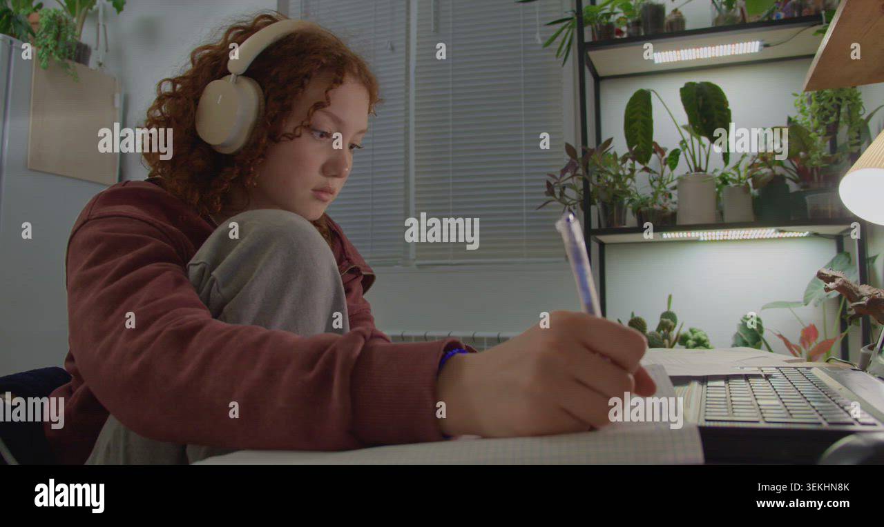Student writing in notebook during online class at home Stock Video ...