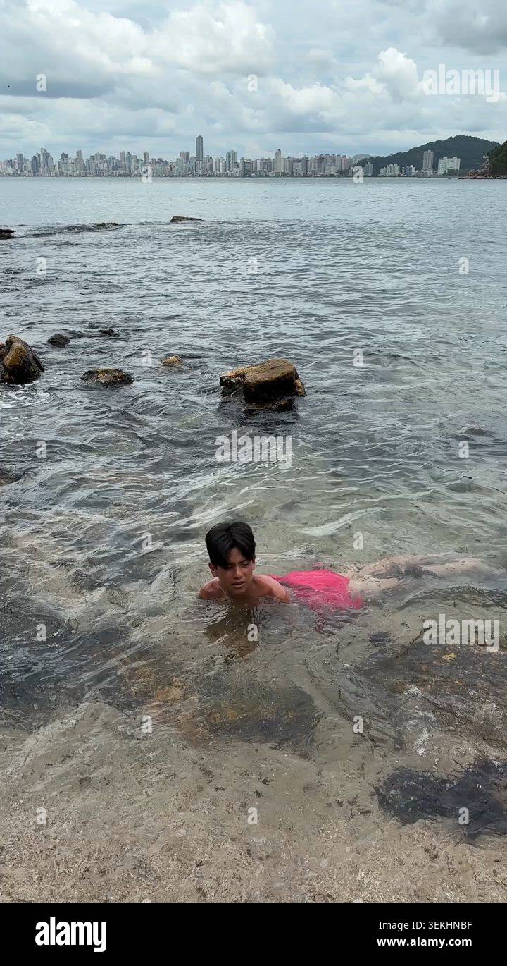 UGC Child Swims in Shallow Water Near City Skyline on Cloudy Day Stock ...