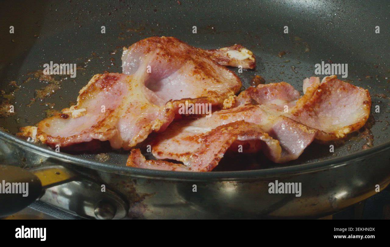 Cooking Bacon in a Frying Pan on a Stove Stock Video Footage - Alamy