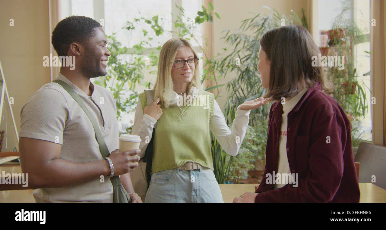 Diverse students laughing and talking together at university campus ...