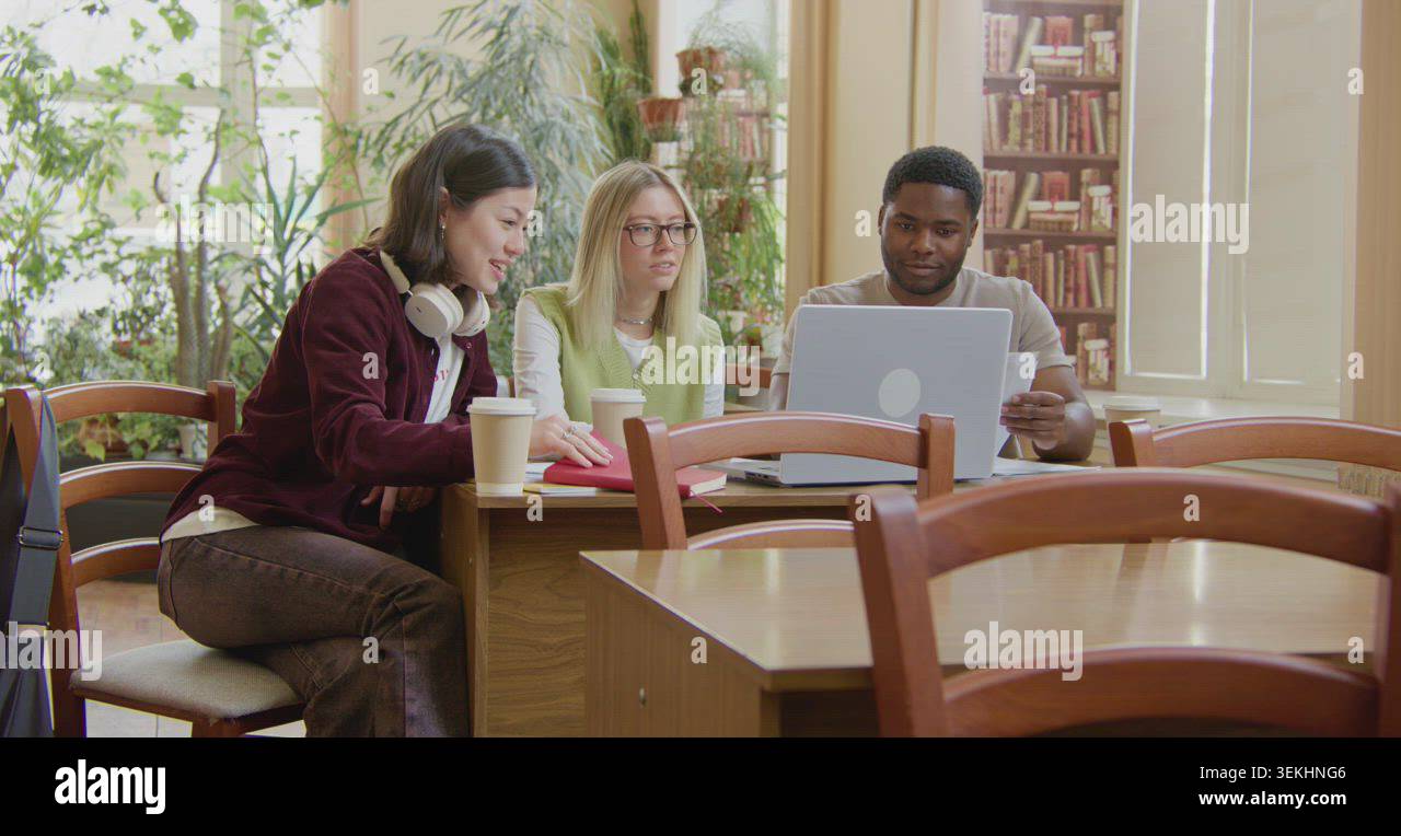 Diverse students collaborating and learning in a university library ...