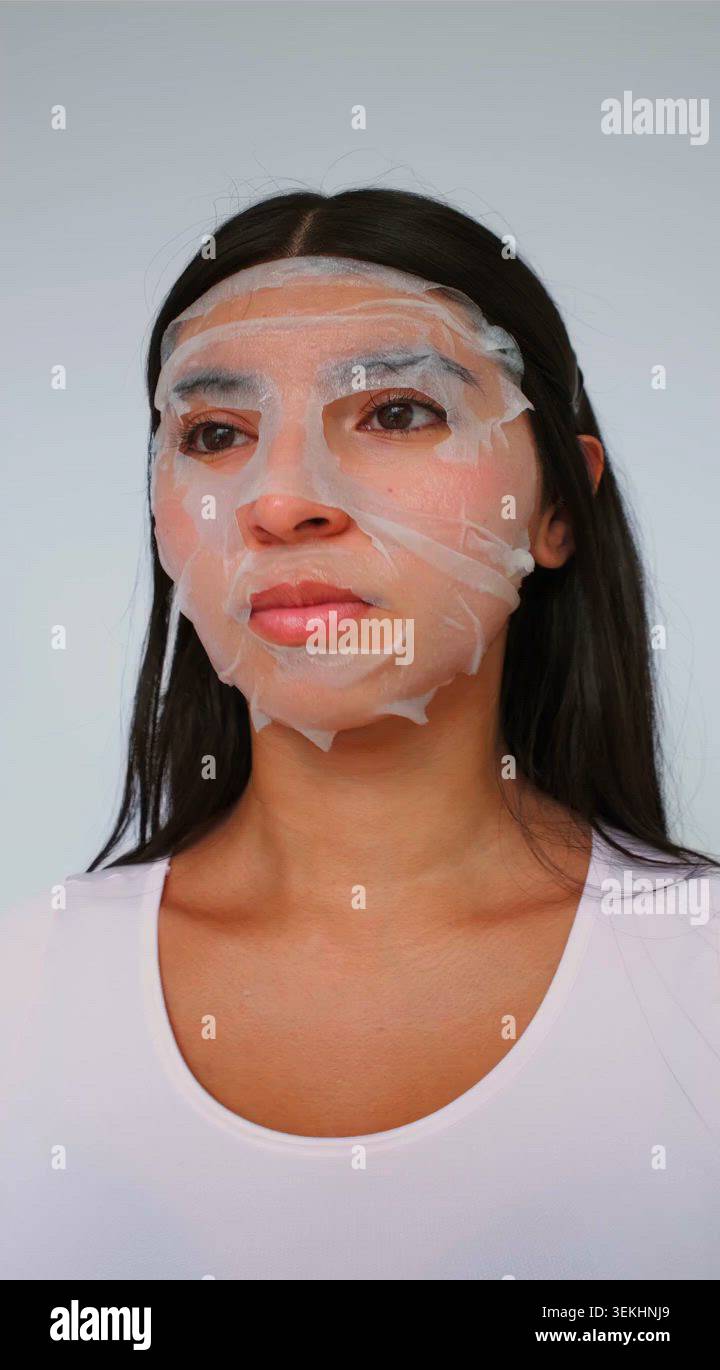 woman applying nourishing facial sheet mask for skincare routine Stock ...