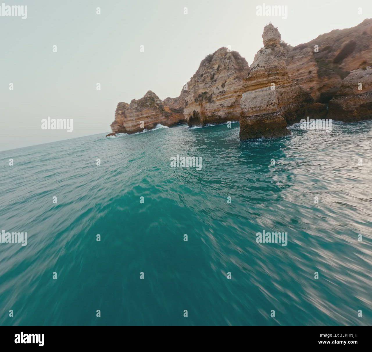FPV drone surfing ocean wave through rock arch in Lagos, Portugal Stock ...