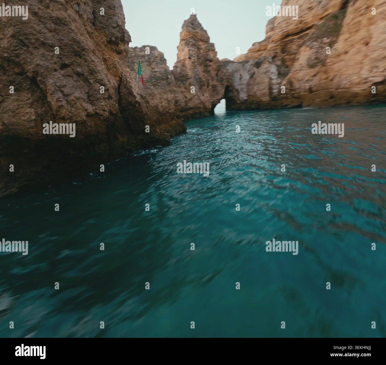 FPV drone through Ponta da Piedade arches at soft sunrise, Portugal ...