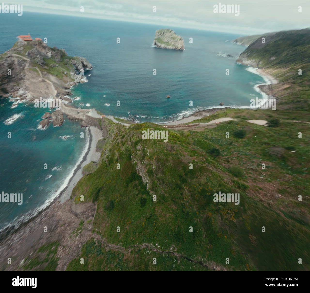 FPV drone wide view and coastal descent at Gaztelugatxe, Spain Stock ...