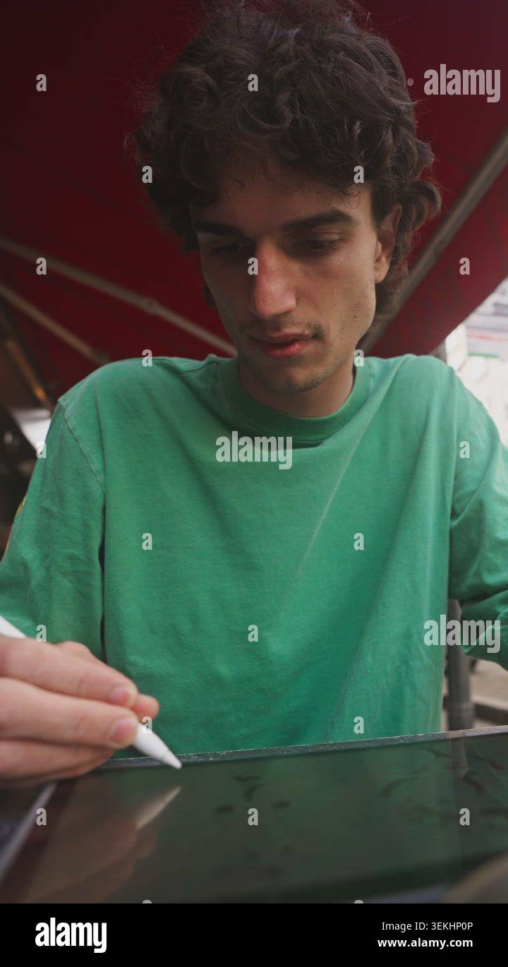 Gen Z guy drawing on a tablet while enjoying coffee in Italy Stock ...