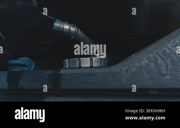 Close-up of a truck driver inserting a fuel nozzle to refill the ...