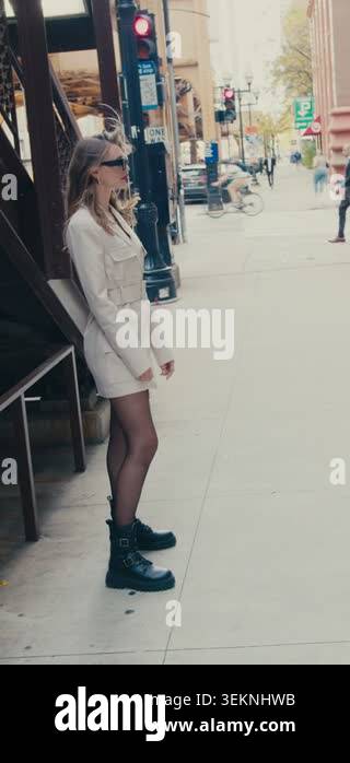 Wide vertical shot of a girl in an urban style on the street of a big ...