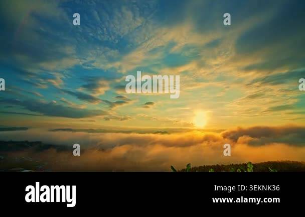 Vibrant sunset over a cloudy sky with golden light illuminating the ...
