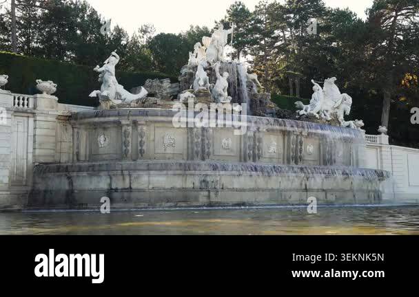 Large stone fountain with sculptural figures and flowing water in ...