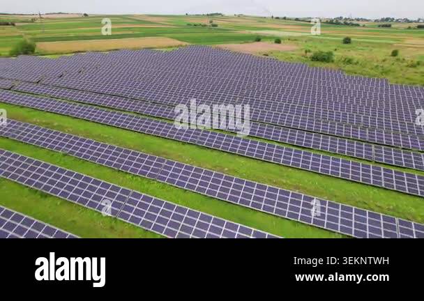Aerial drone shot of solar arrays covering large grassland area. Modern ...
