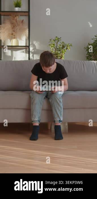 Young boy engrossed in a mobile game on a tablet while sitting on a ...