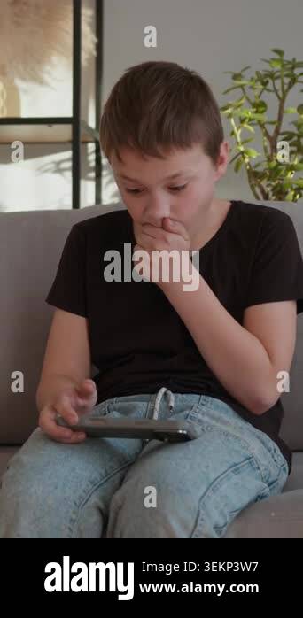Young boy engrossed in mobile gaming, showing concentration and ...