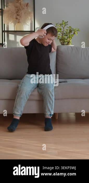 Young boy wearing headphones engrossed in playing a video game on his ...