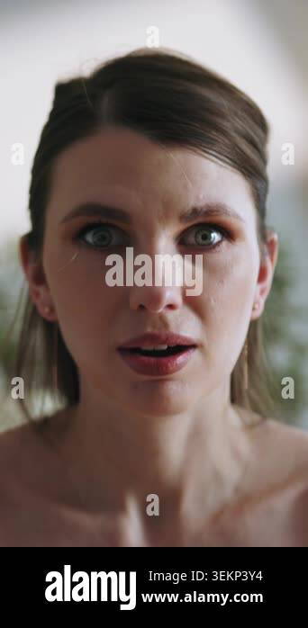 Close-up of womans face showing surprise, covering mouth, then looking ...