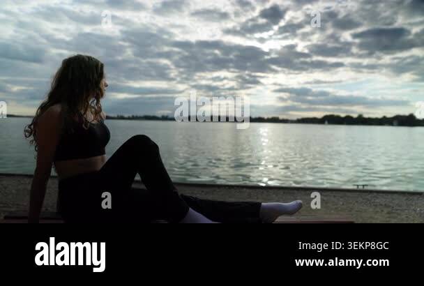 A beautiful and serene scene of a person deeply reflecting by the calm ...