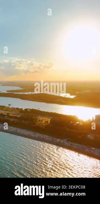 Wide aerial sunset view of Miami Beach with lens flare sun over ...