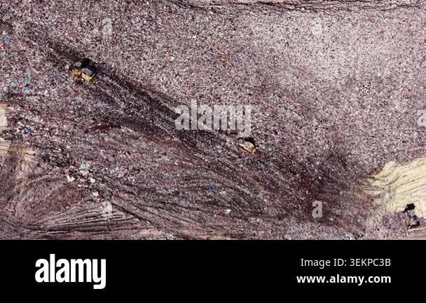 High angle drone shot detailing heavy vehicles creating tracks through ...