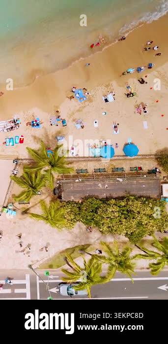 Overhead aerial view of Waikiki sandy beach with sunbathers, blue ...