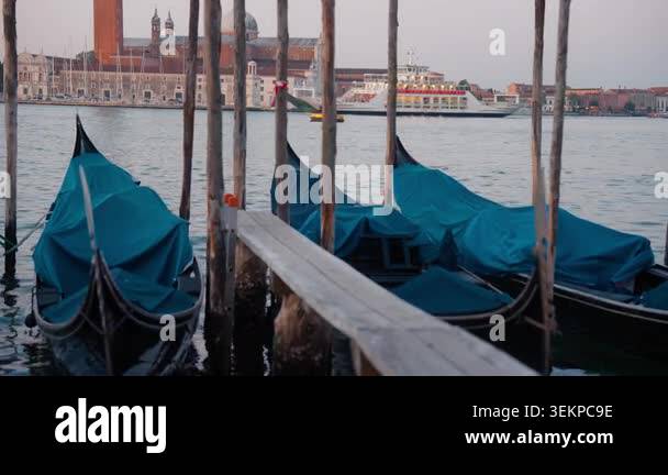 Traditional Venetian gondolas near pier in Venice. Historic ...