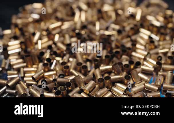 Golden bullet shells sorting and moving on a blue conveyor belt during ...