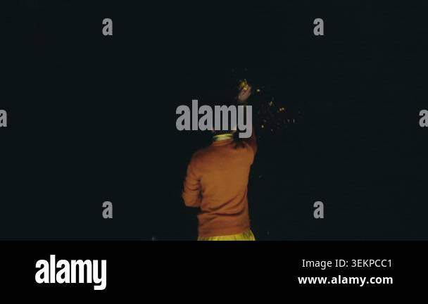 Back view of a Hindu man scattering yellow flower petals into the ...