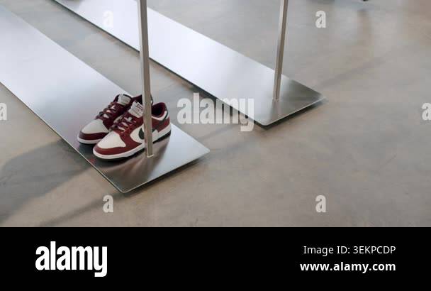 Stylish sneakers displayed on a sleek metal stand in a modern shoe ...