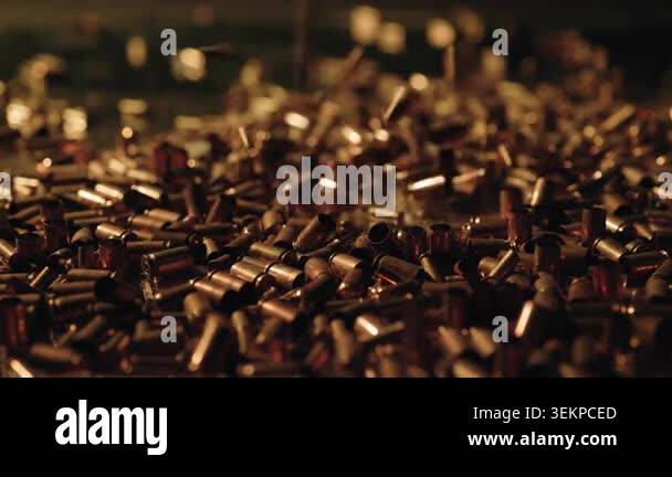 Golden bullet shells falling in slow motion, accumulating into a large ...