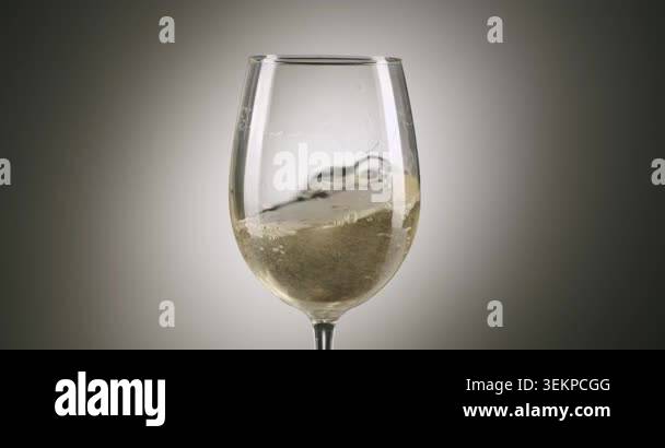 Elegant white wine swirling in a transparent glass, creating ...