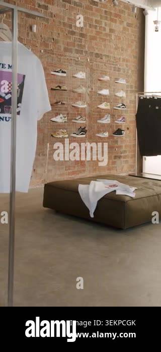 A trendy board shop with a brick wall, displaying a variety of sneakers ...