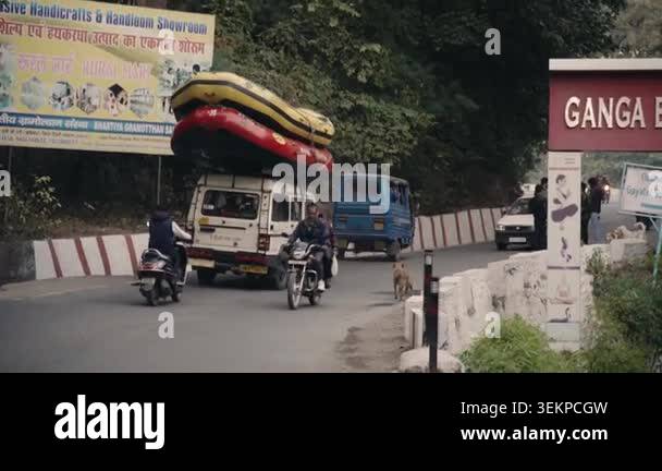 Busy traffic on a mountain road in Rishikesh, with a car transporting ...