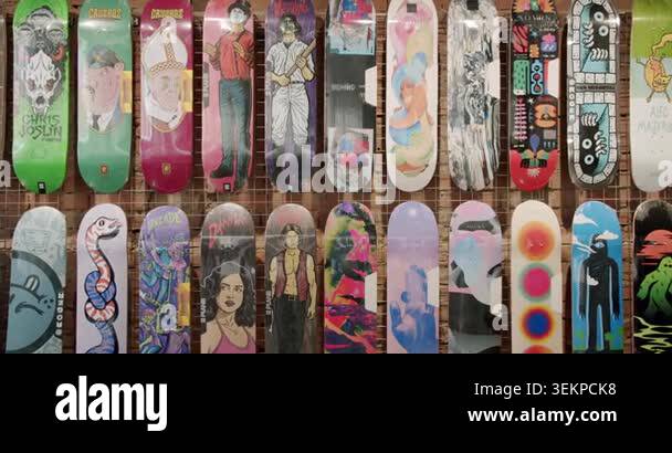 Skateboards displayed on a wall in a skate shop. Colorful skateboard ...