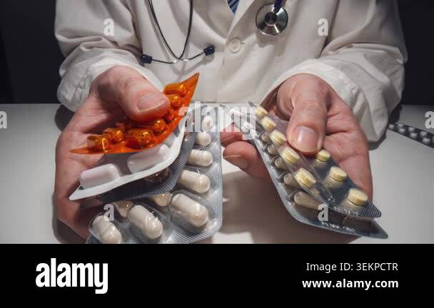 Doctor is holding too many drugs and pills in hands. Overdosage concept ...