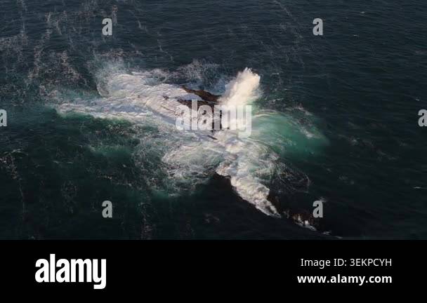 Waves crash against rugged rocks in a powerful ocean display Stock ...