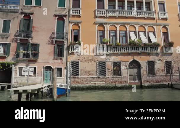 Historic buildings with weathered walls, arched windows, balconies, and ...