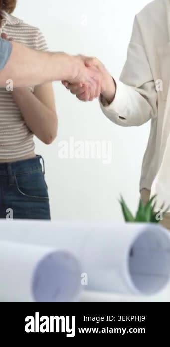 Architects and clients shaking hands, confirming an agreement for a new ...
