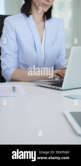 Professional businesswoman typing on a laptop computer, focusing on her ...