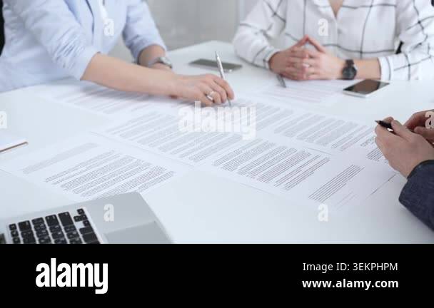 Professionals collaborating around a white table. Examining contract ...